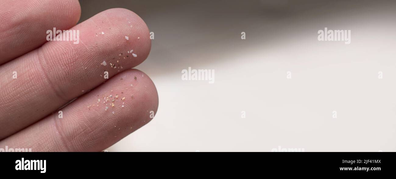 Micro plastic particles on a human finger for scale. Concept for water ...