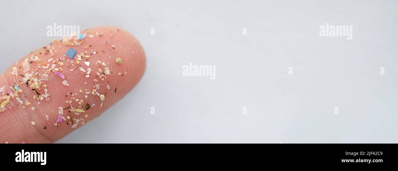 Micro plastic particles on a human finger for scale. Concept for water ...