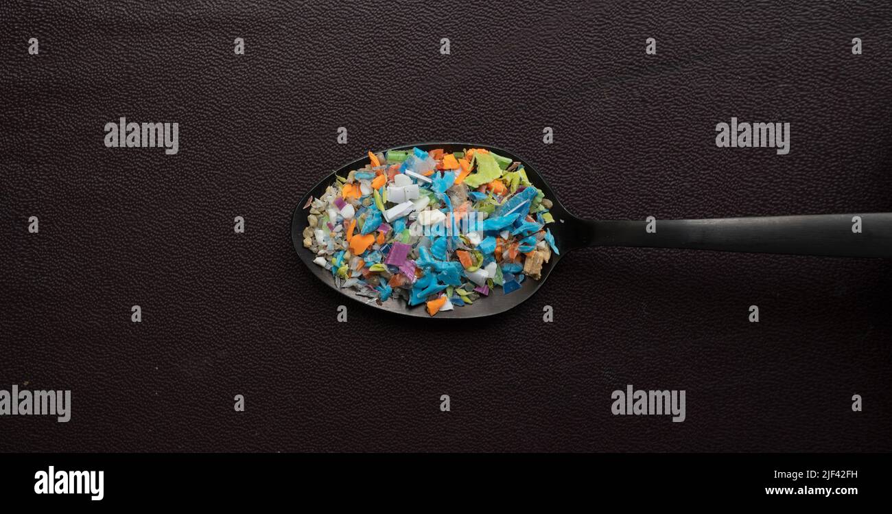 Close-up top shot of microplastic particles in a spoon. Concept for ...