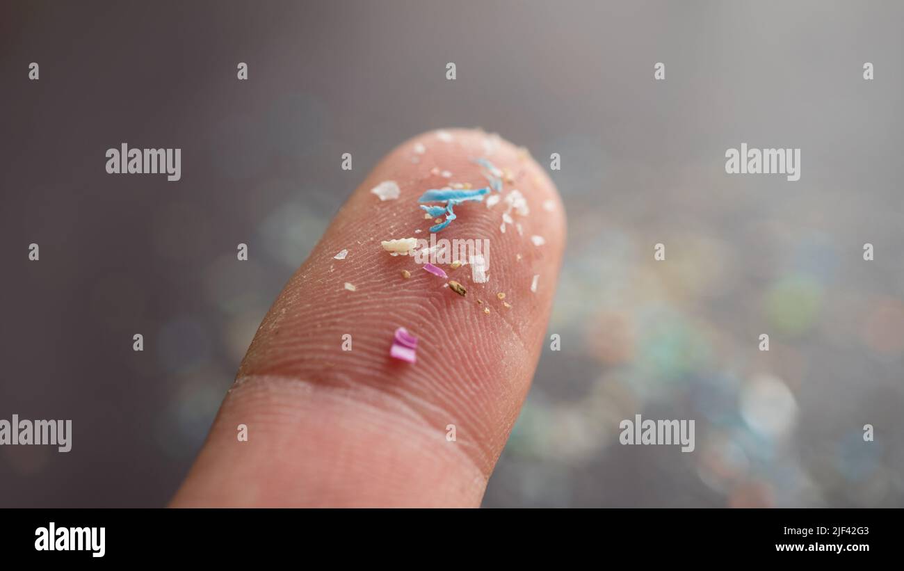 Micro plastic particles on a human finger for scale. Concept for water ...