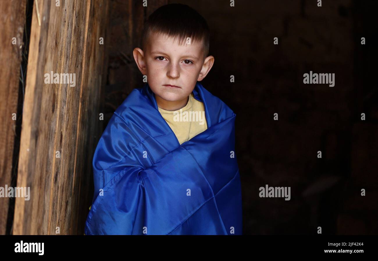 sad Ukrainian small child stands outdoors supporting homeland, little ...