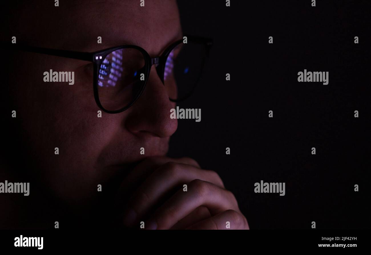 male working online late. Close up side view of focused man wears ...