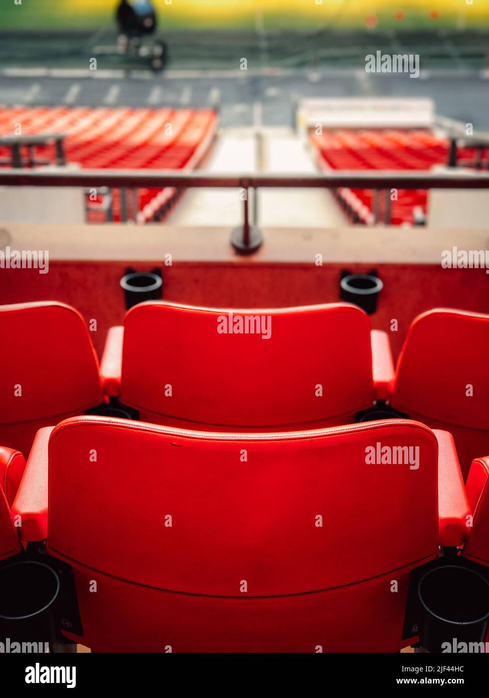 A shallow focus shot of red and empty auditorium seats from the back ...