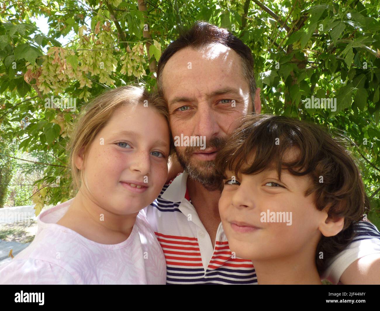 a bearded father embraces his daughter and son Stock Photo - Alamy