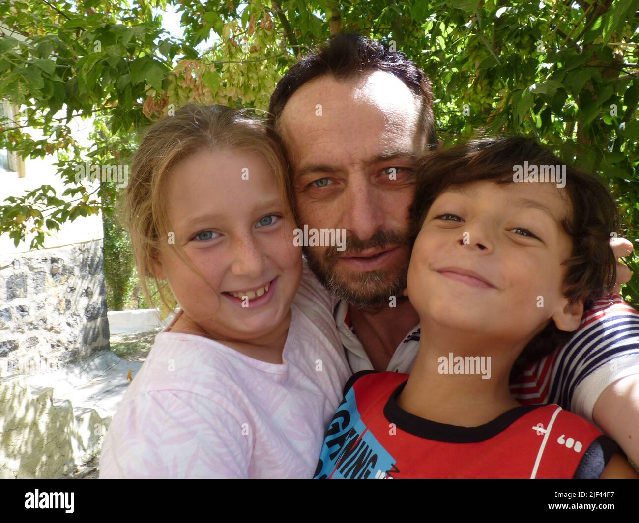 a bearded father embraces his daughter and son Stock Photo - Alamy