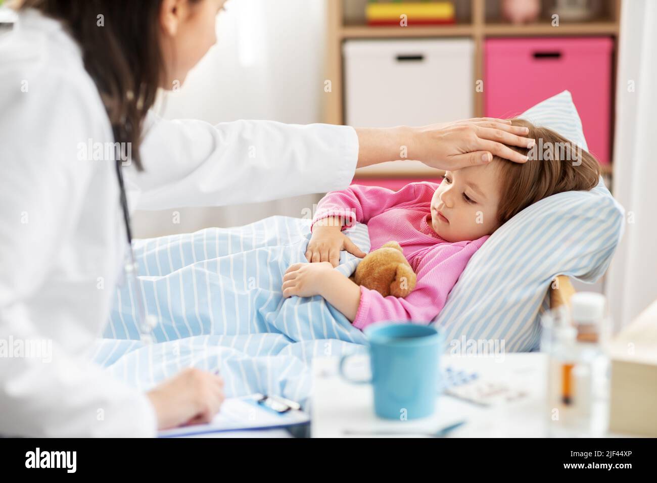 doctor measuring sick girl's temperature at home Stock Photo - Alamy