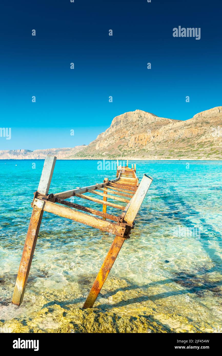 Old rusty jetty on the amazing crystal clear water of Balos Lagoon ...