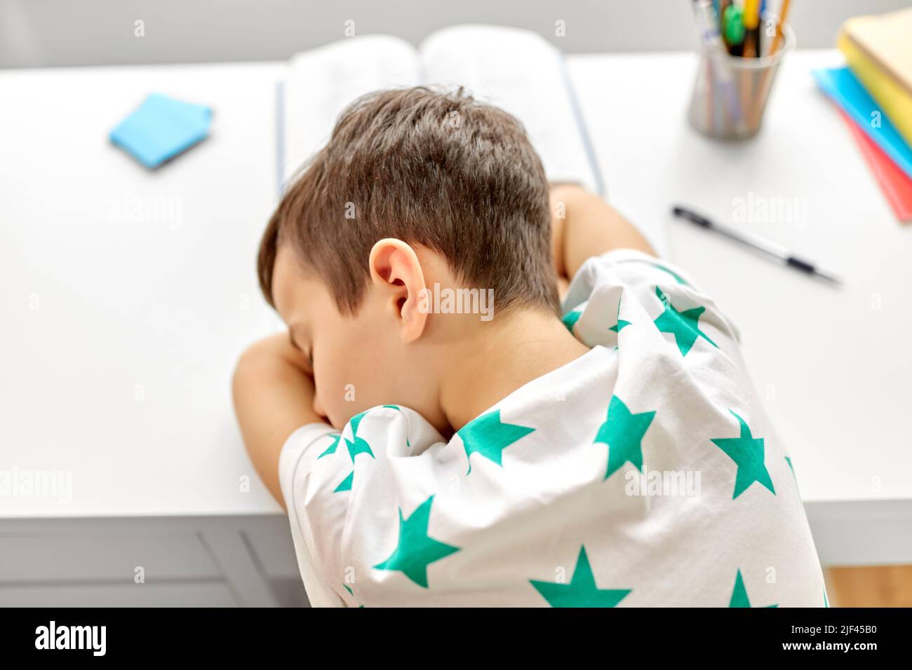 close up of tired boy sleeping on table at home Stock Photo - Alamy