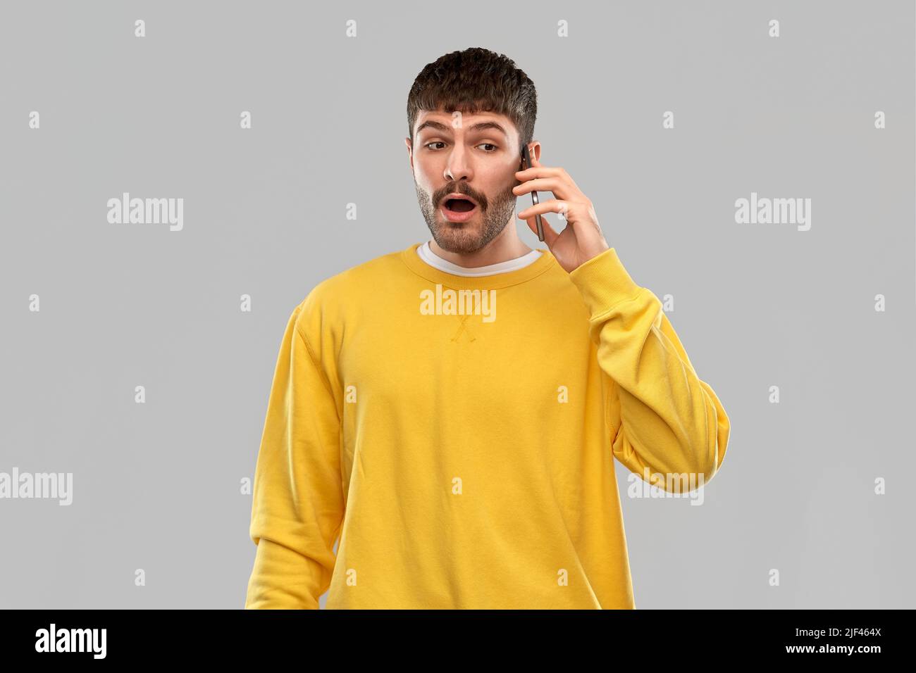 shocked young man calling on smartphone Stock Photo - Alamy