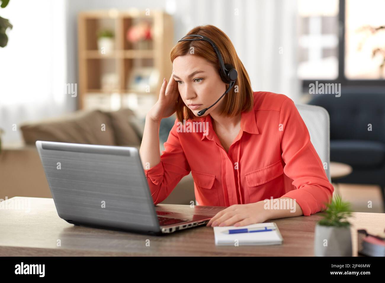 sad woman with headset and laptop working at home Stock Photo - Alamy
