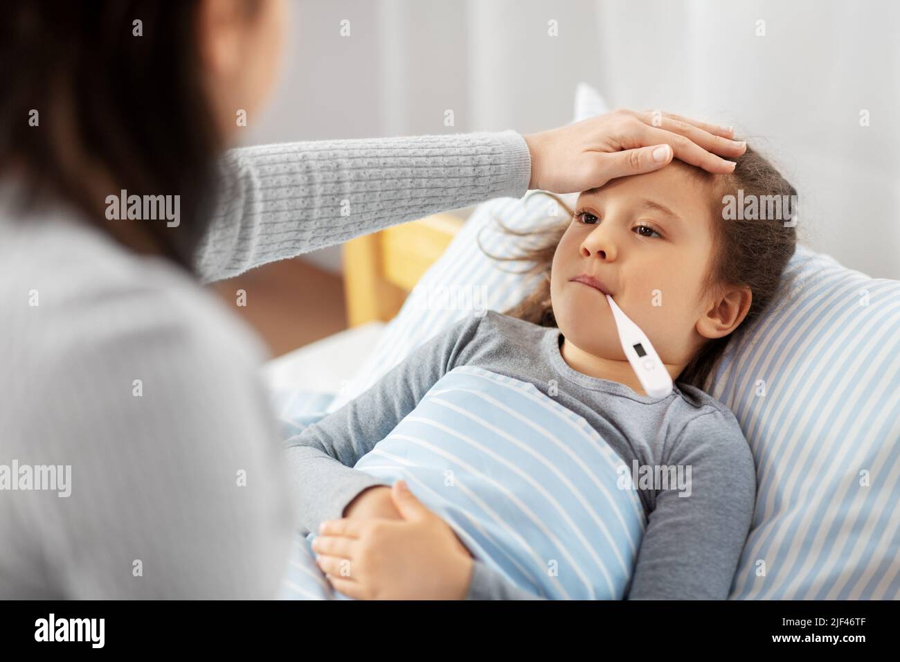 mother and sick daughter measuring temperature Stock Photo - Alamy