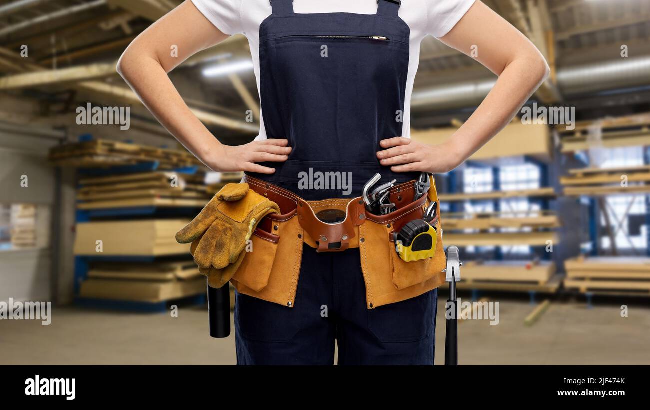 female worker with tools on belt at factory Stock Photo - Alamy