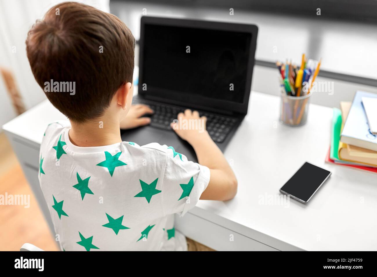 student boy typing on laptop computer at home Stock Photo - Alamy