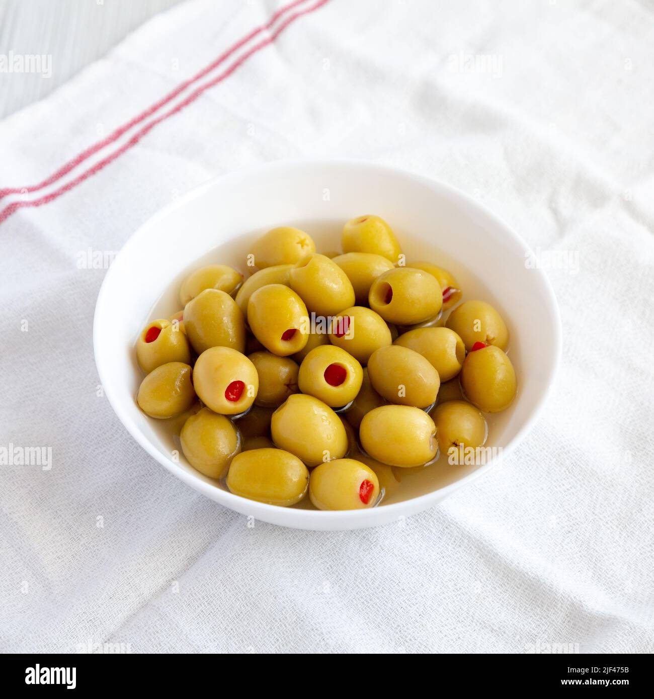 Marinated Green Olives with Pimento Peppers in a Bowl, side view Stock ...