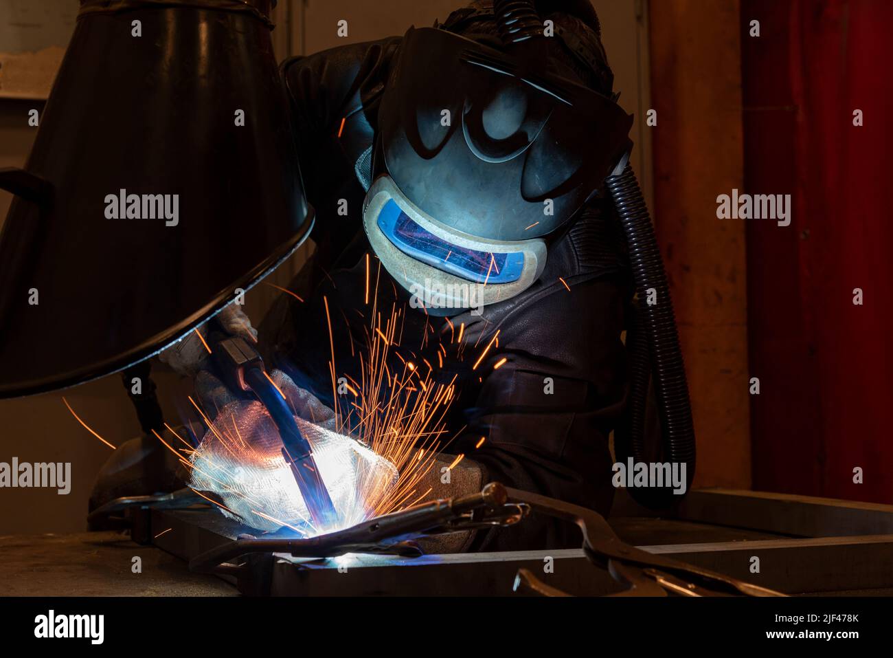 Workers wearing industrial uniforms and Welded Iron Mask at Steel ...