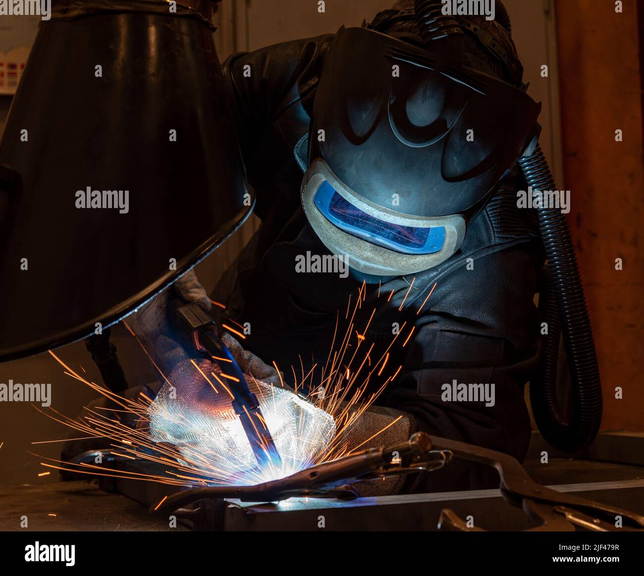 Workers wearing industrial uniforms and Welded Iron Mask at Steel ...