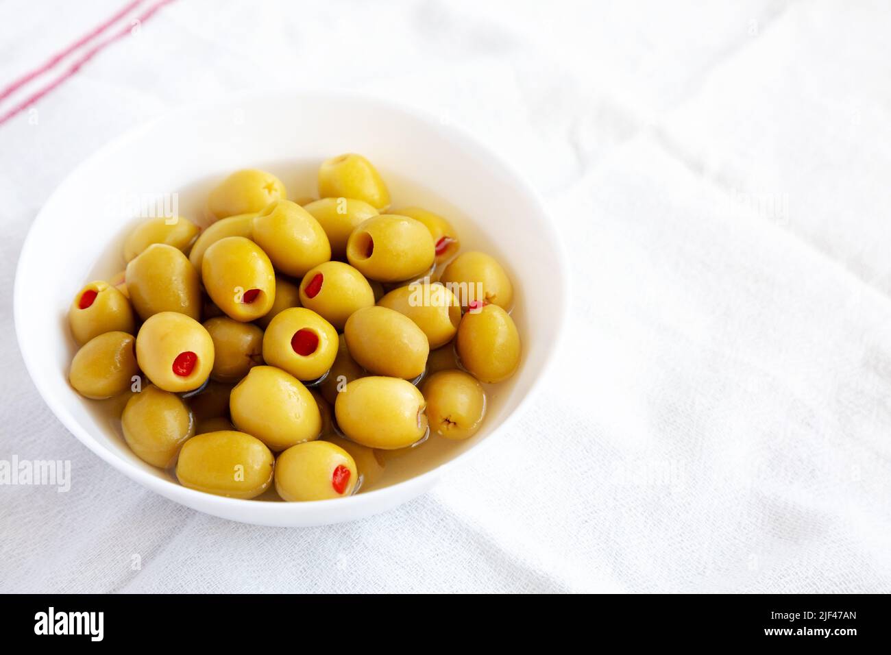 Marinated Green Olives with Pimento Peppers in a Bowl, side view Stock ...