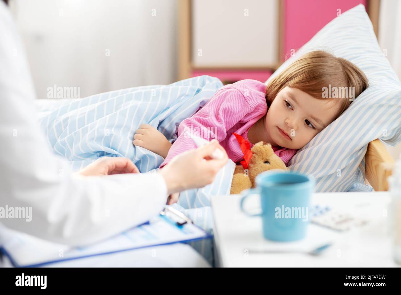 doctor measuring sick girl's temperature at home Stock Photo - Alamy