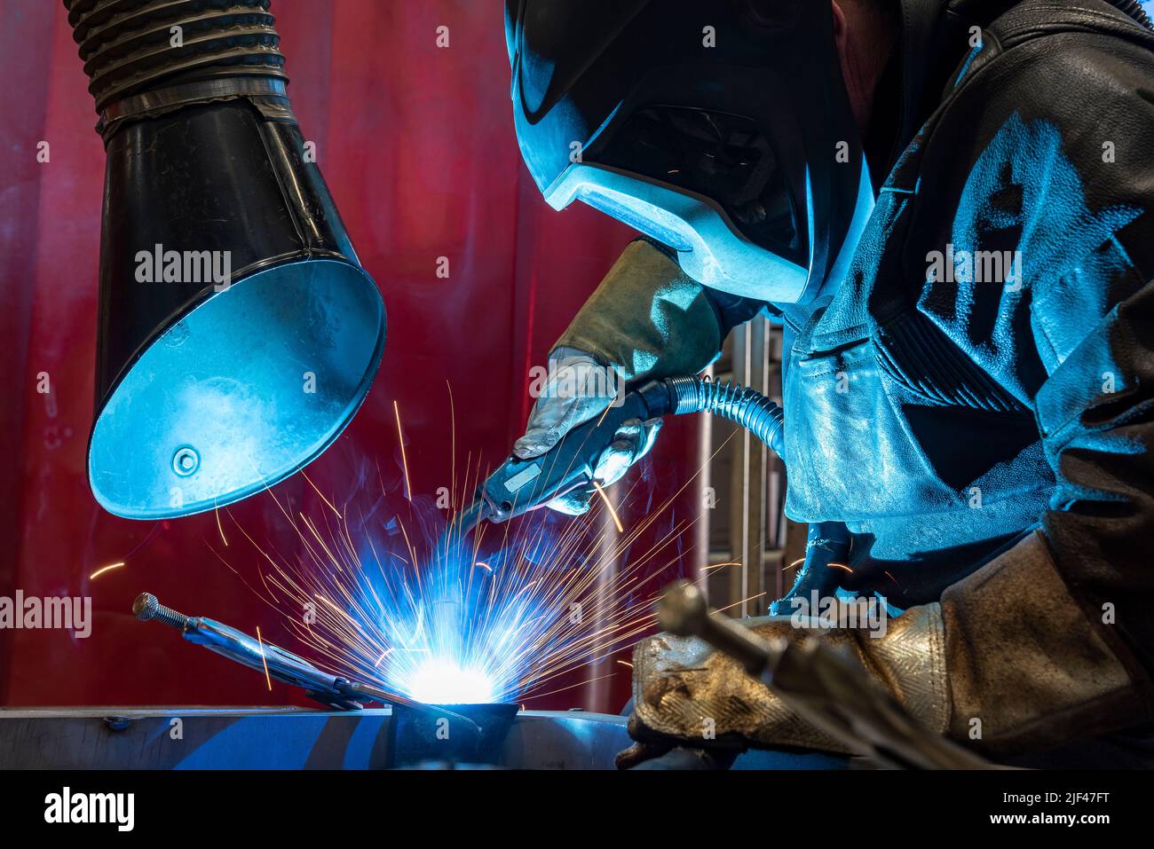 Workers wearing industrial uniforms and Welded Iron Mask at Steel ...