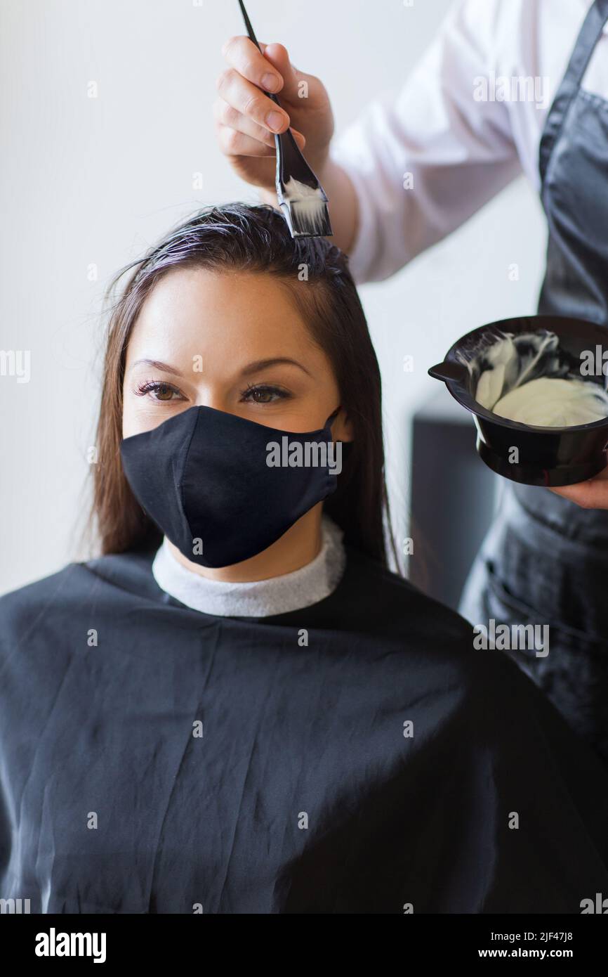 happy woman with stylist coloring hair at salon Stock Photo - Alamy