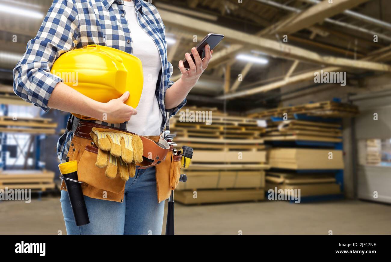female worker with phone and tools at factory Stock Photo - Alamy