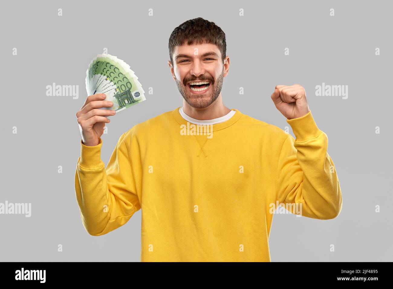 happy young man with money celebrating success Stock Photo - Alamy