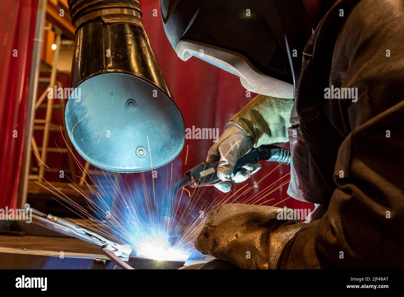 Workers wearing industrial uniforms and Welded Iron Mask at Steel ...