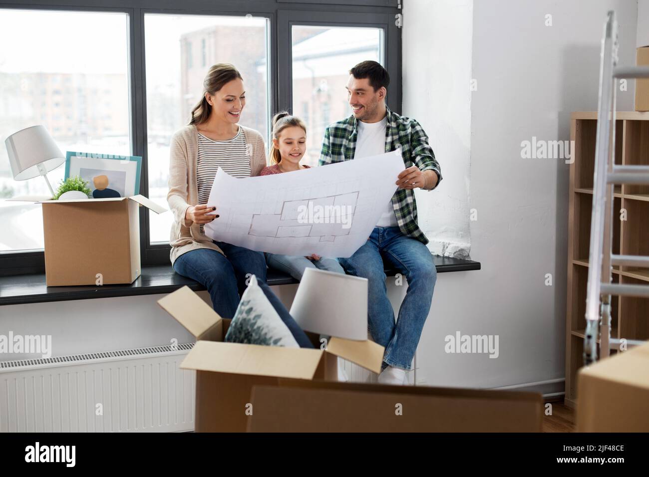 happy family with blueprint moving to new home Stock Photo - Alamy