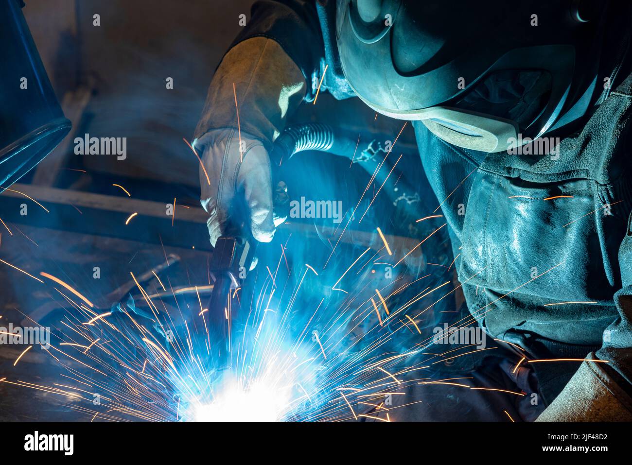 Workers wearing industrial uniforms and Welded Iron Mask at Steel ...