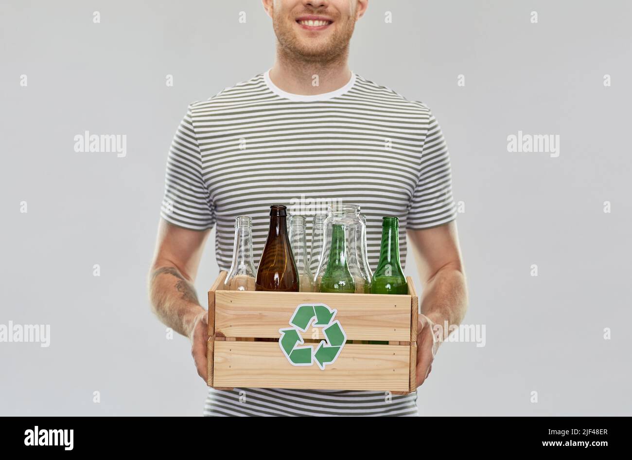 smiling young man sorting glass waste Stock Photo - Alamy