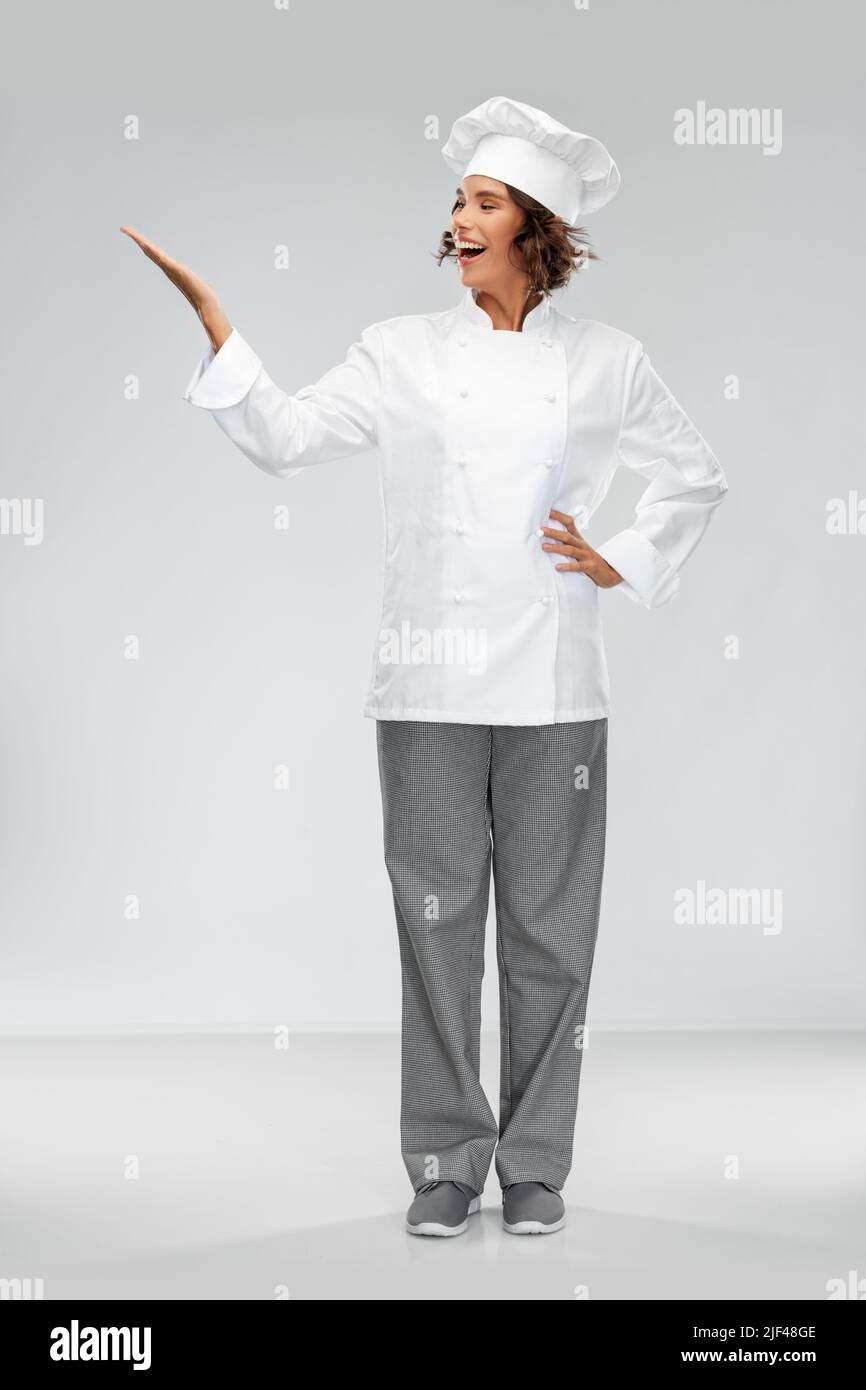 smiling female chef holding something on hand Stock Photo - Alamy