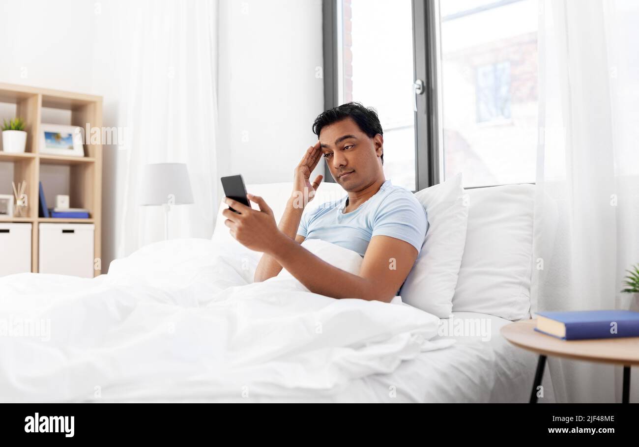 Man looking cell phone bed hi-res stock photography and images - Alamy