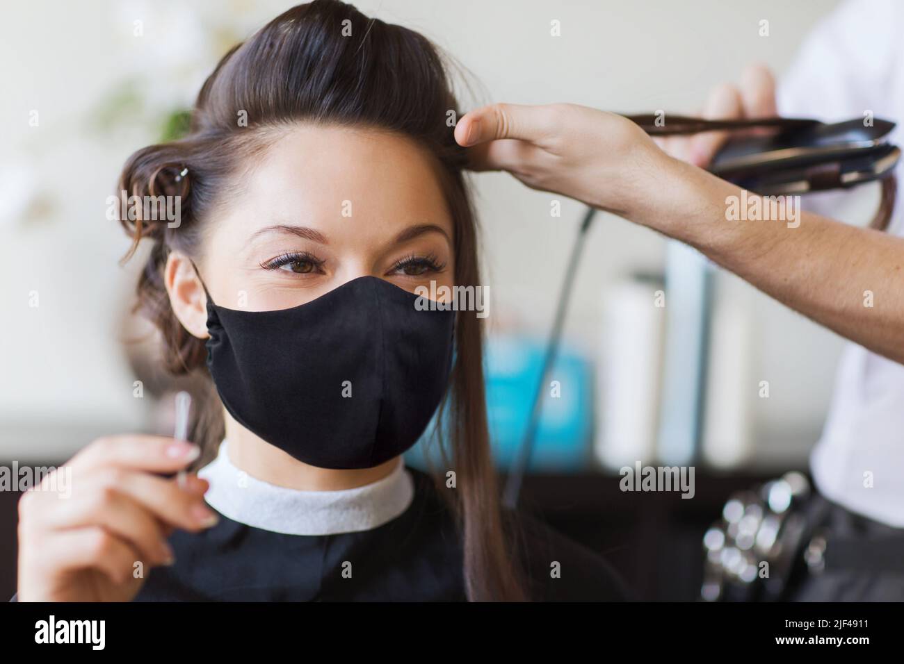 happy woman with stylist making hairdo at salon Stock Photo - Alamy
