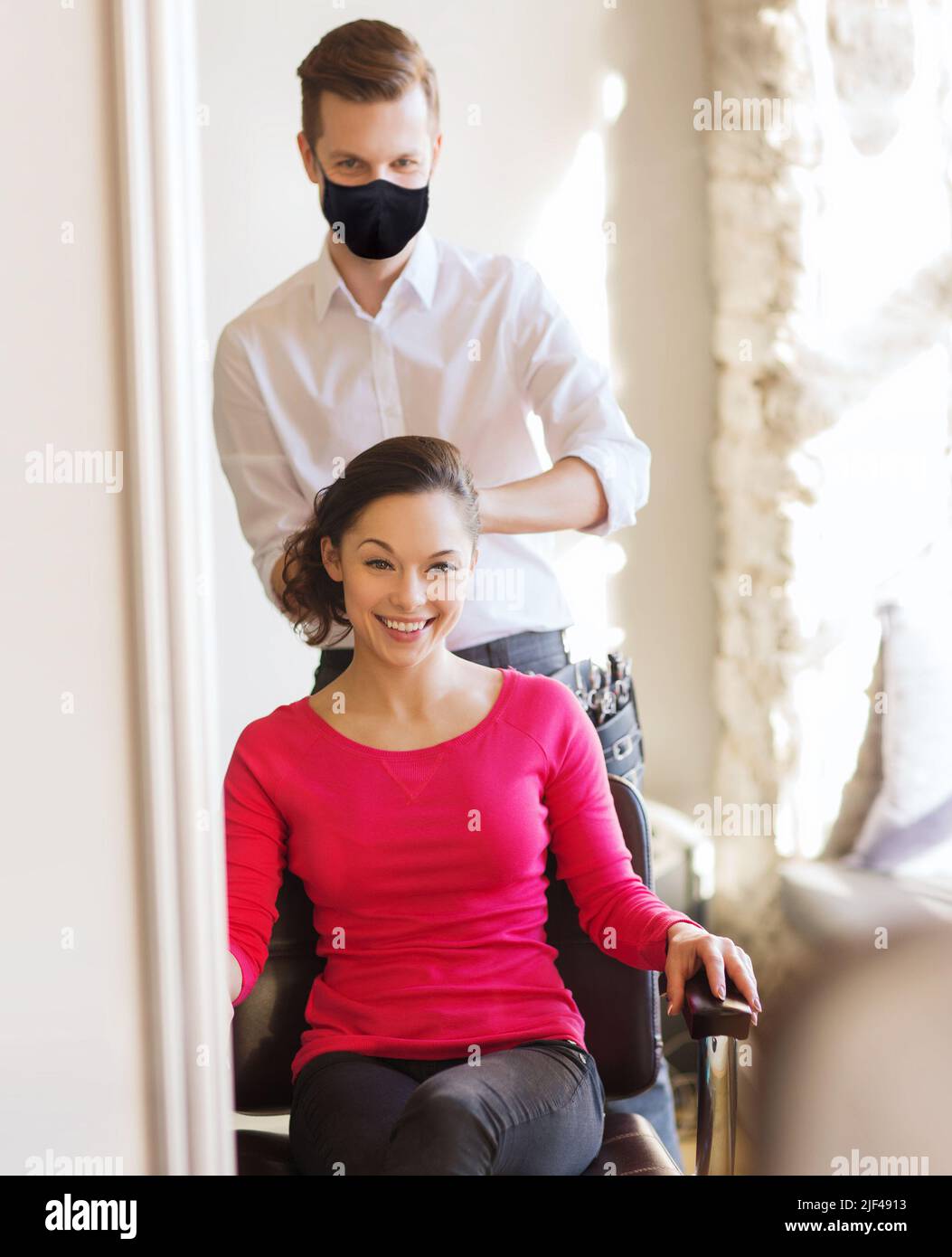 happy woman with stylist making hairdo at salon Stock Photo - Alamy