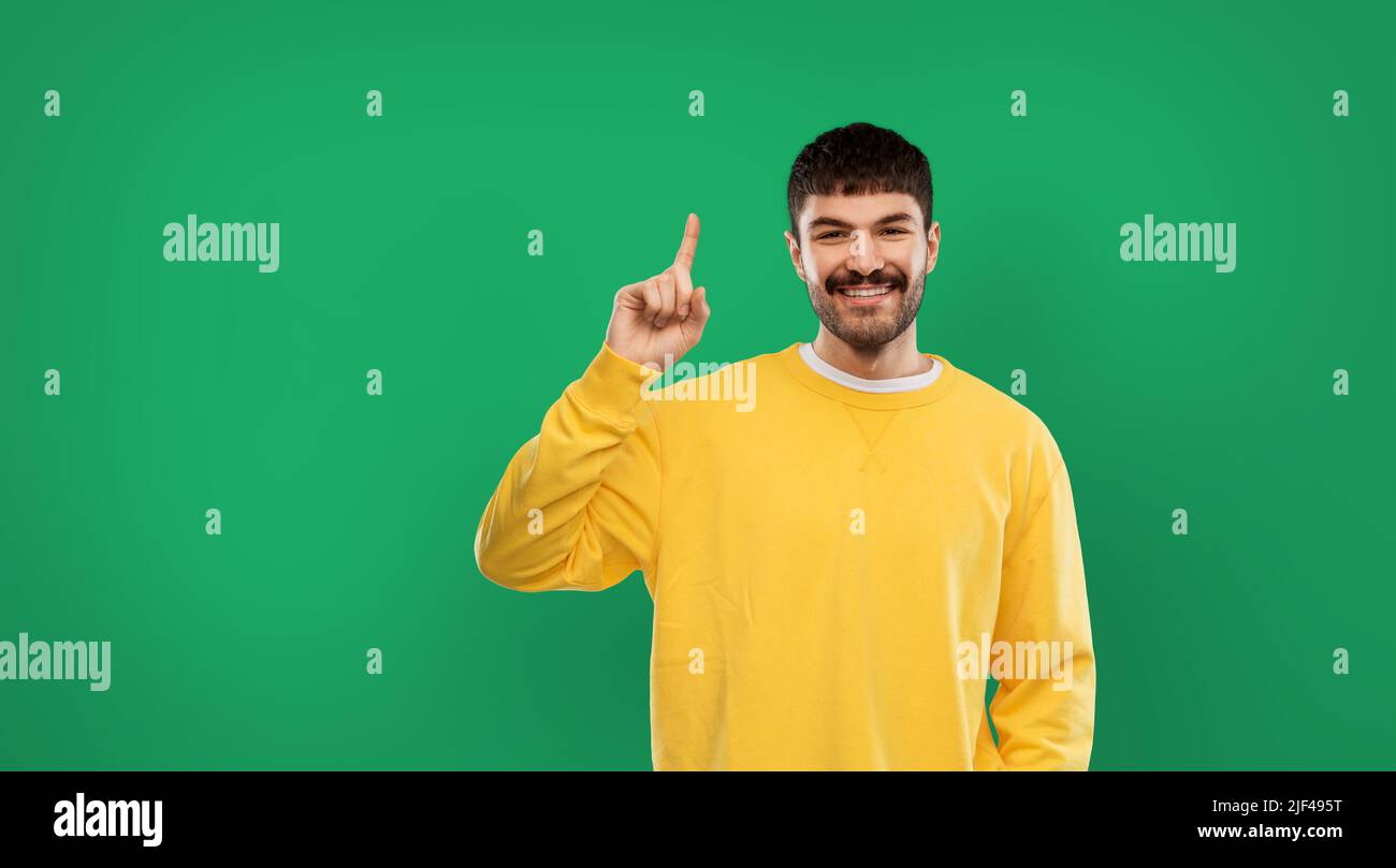 happy man pointing finger up over green Stock Photo - Alamy
