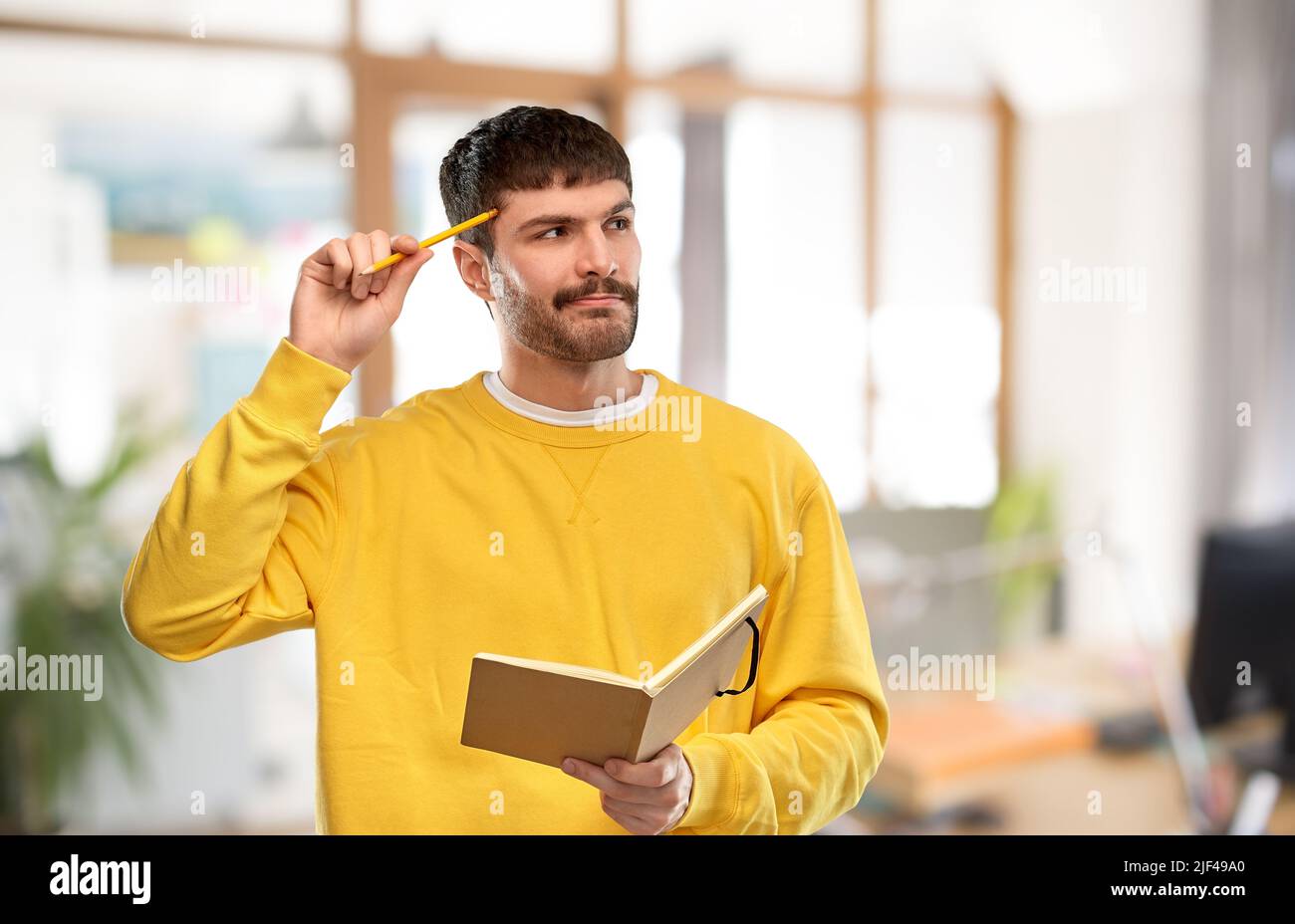 thinking man with diary and pencil over office Stock Photo - Alamy