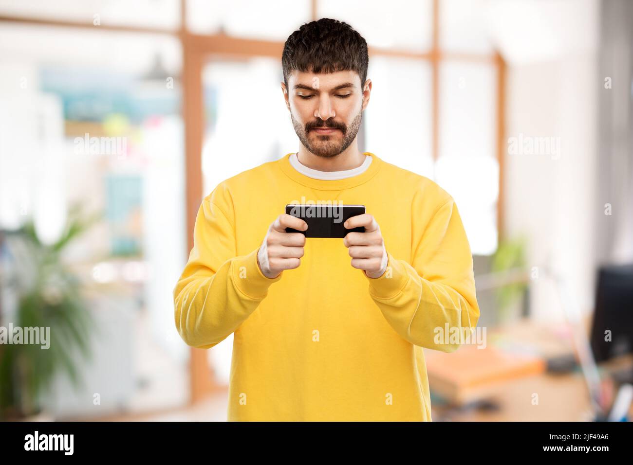 young man playing game on smartphone Stock Photo - Alamy