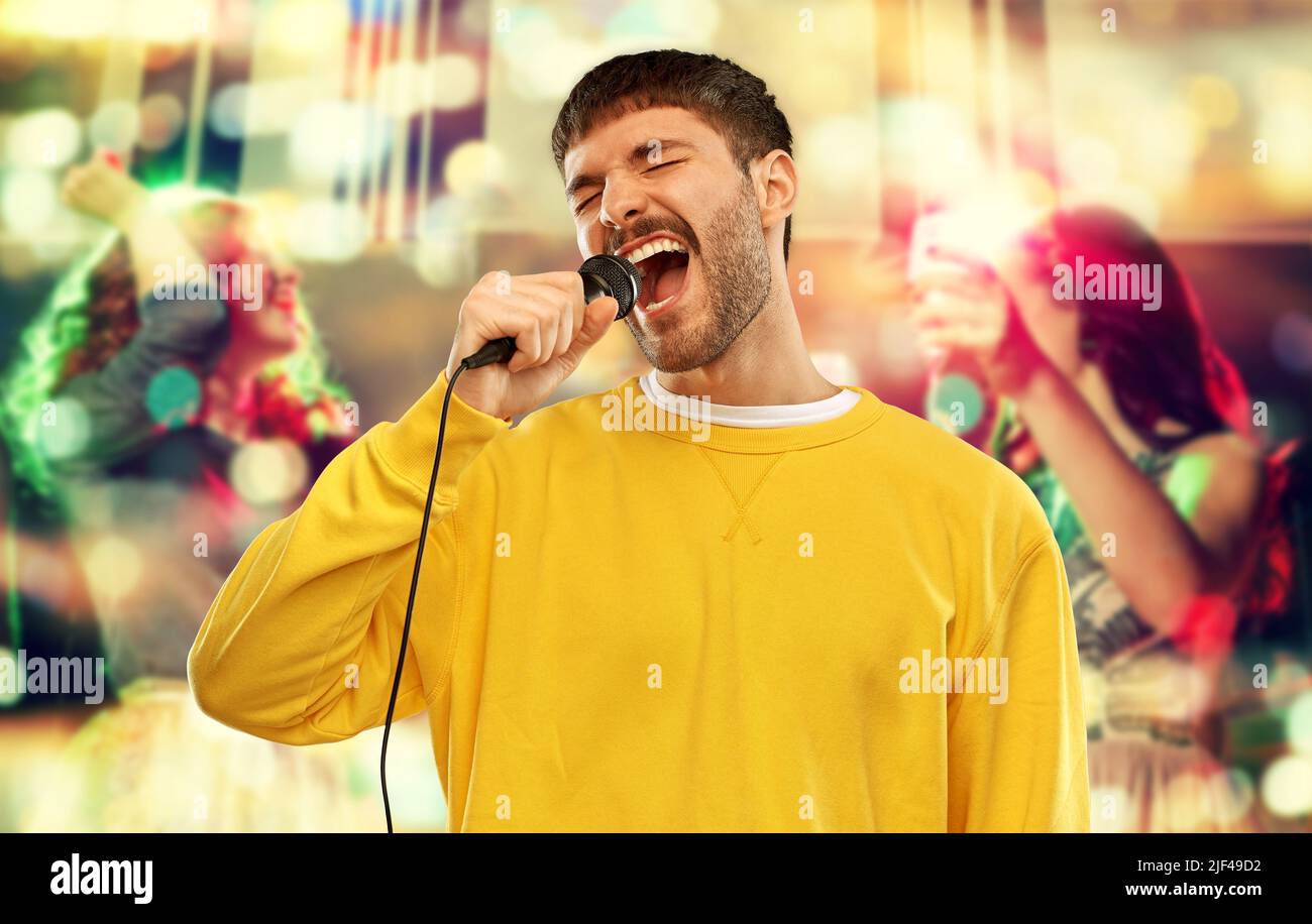 man with microphone singing at night club Stock Photo - Alamy