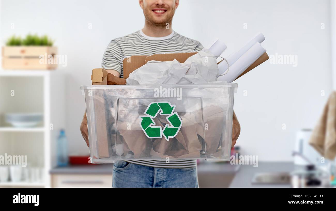 smiling young man sorting paper waste Stock Photo - Alamy