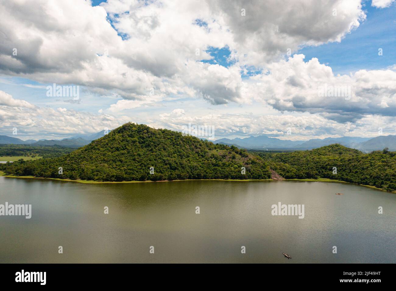Aerial drone of valley with a lake and tropical vegetation against a ...