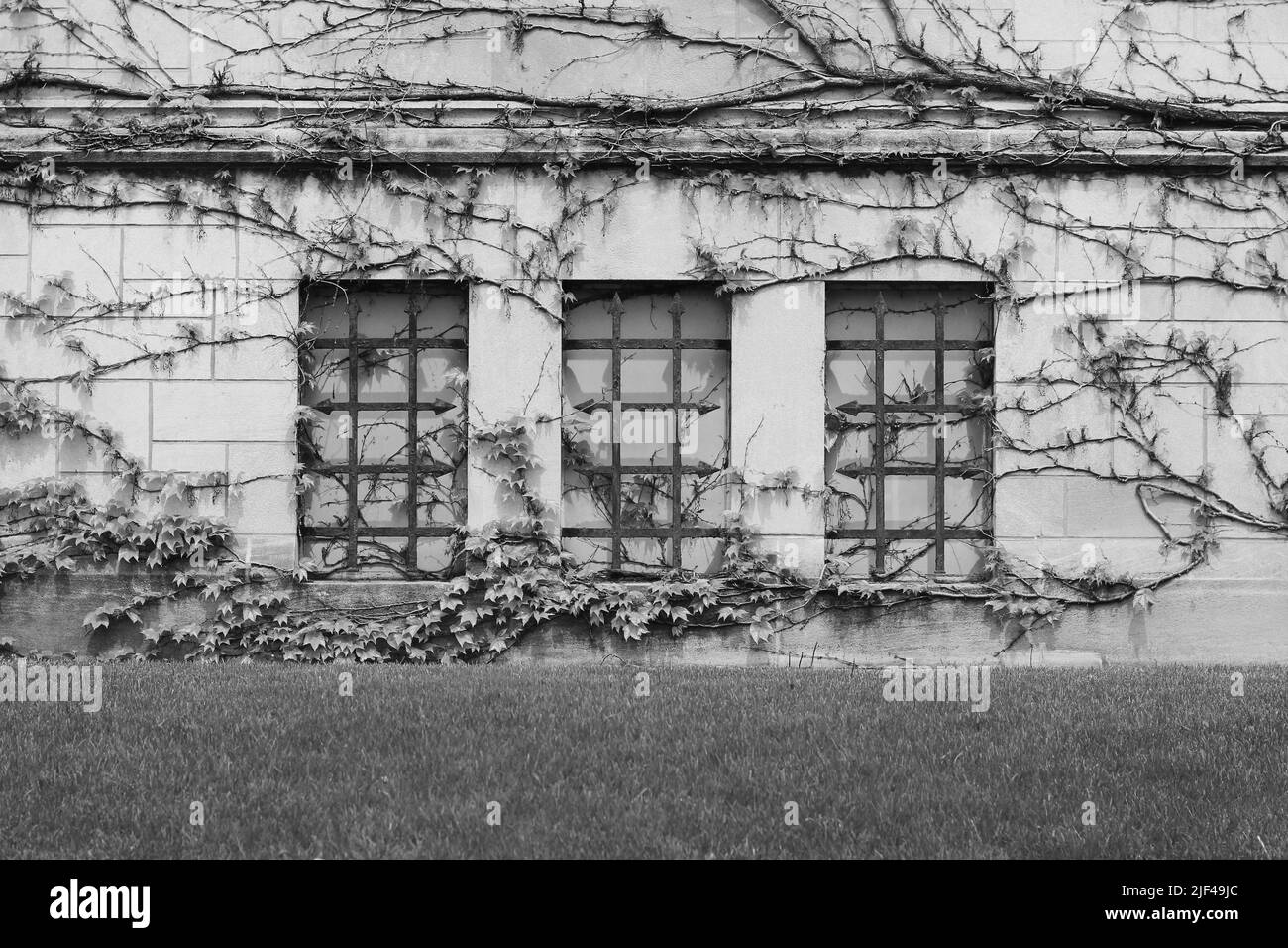 A triplicate of three windows on a fancy stone wall building in black ...