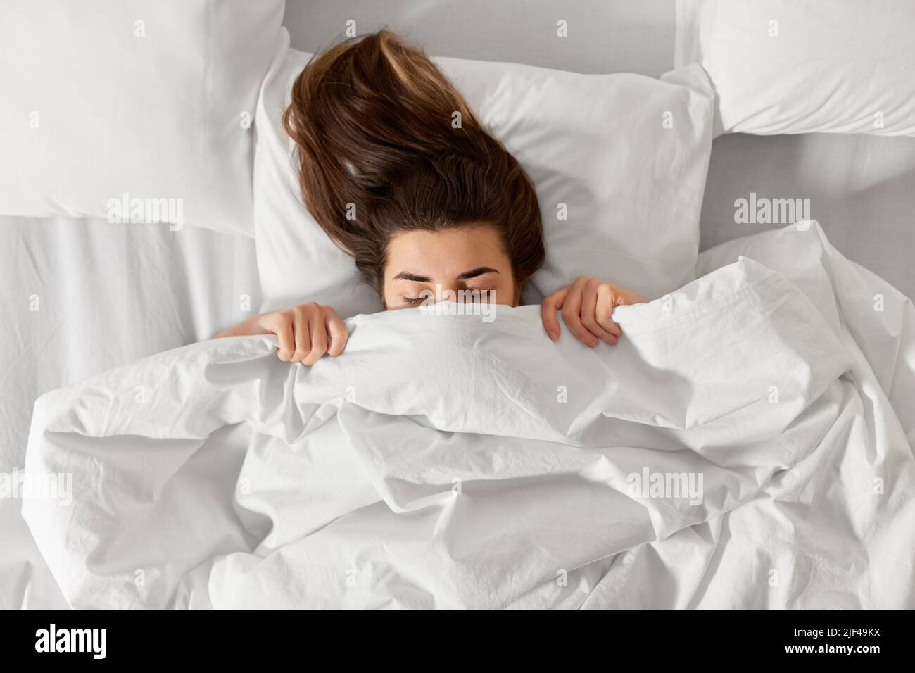 Woman hiding under blanket hi-res stock photography and images - Alamy