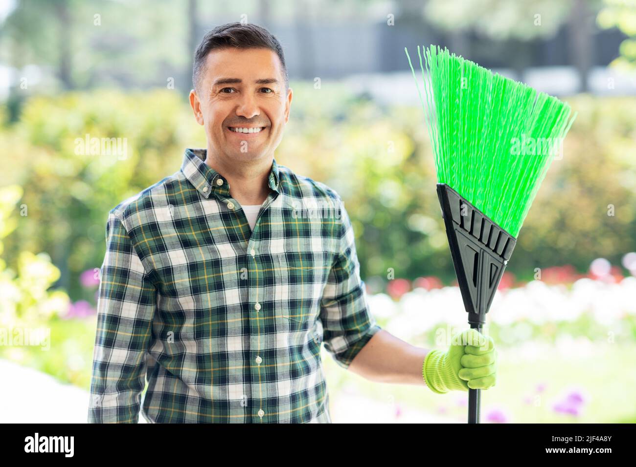 happy middle-aged man with broom at garden Stock Photo - Alamy