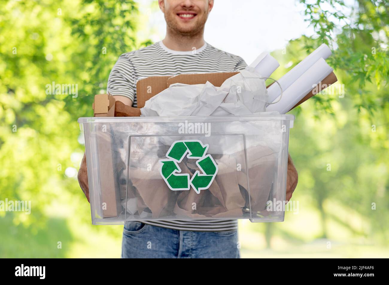 smiling young man sorting paper waste Stock Photo - Alamy