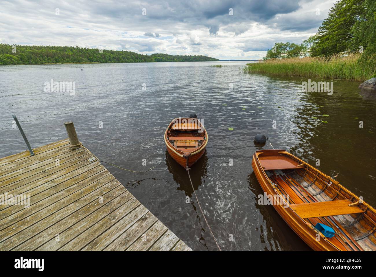 Beautiful view of lake with two boats parked on shore of pier against ...