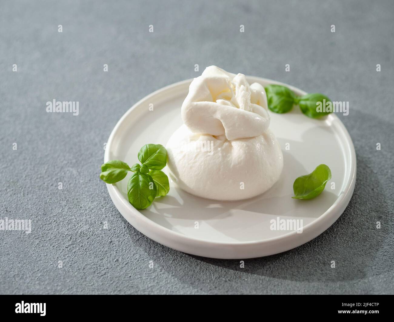 Fresh Italian cheese on plate. White ball of burrata or burratina ...