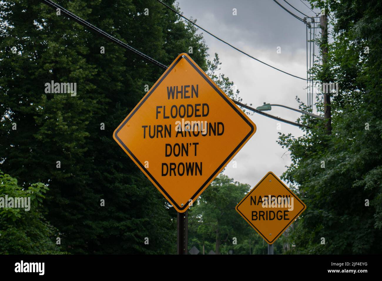 A closeup of orange signs with text in the park. When flooded turn ...