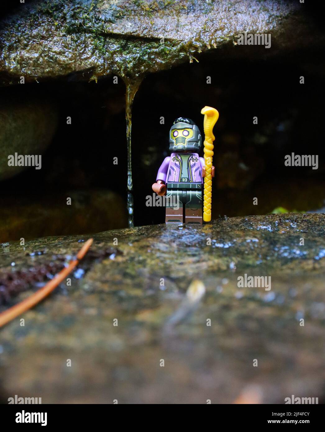 A vertical closeup shot of the Marvel mini figure Star-Lord on a stone ...