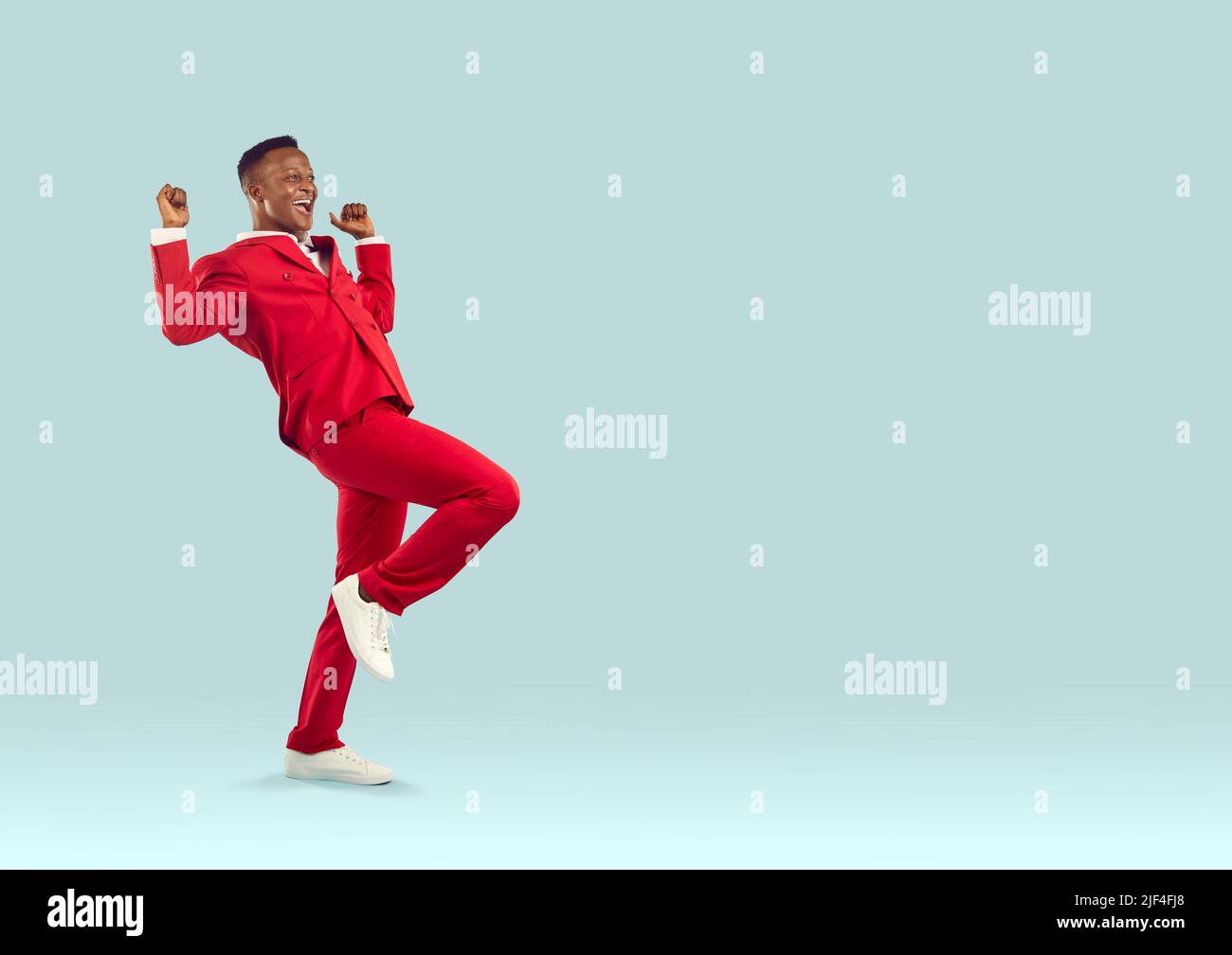 Cheerful excited African American man in funky suit celebrating victory ...