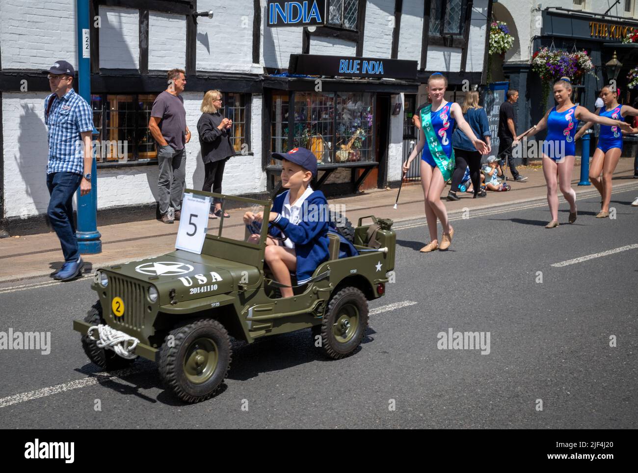 A young boy drives a toy electric Jeep, painted in US Army colours, in ...